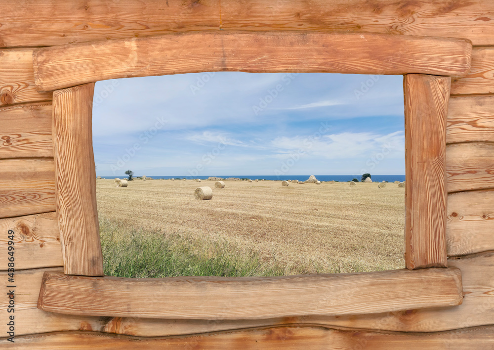 A window frame in a wooden cabin, revealing a gorgeous Apulian panorama ...