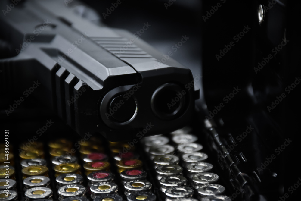 Automatic black 9mm pistol and bullets on blurred black leather ...