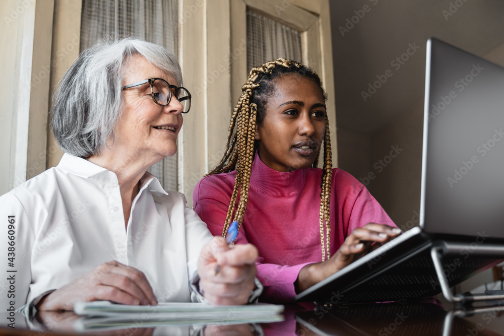 Multiracial young and senior people using computer laptop indoor at ...