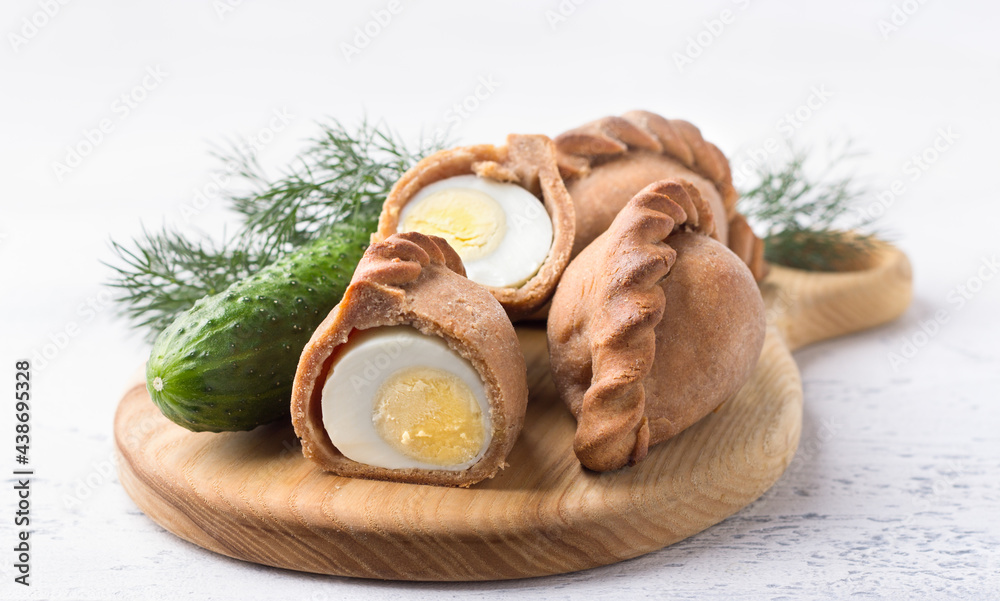 Russian traditional rye pies with egg, kokurki, on light gray ...