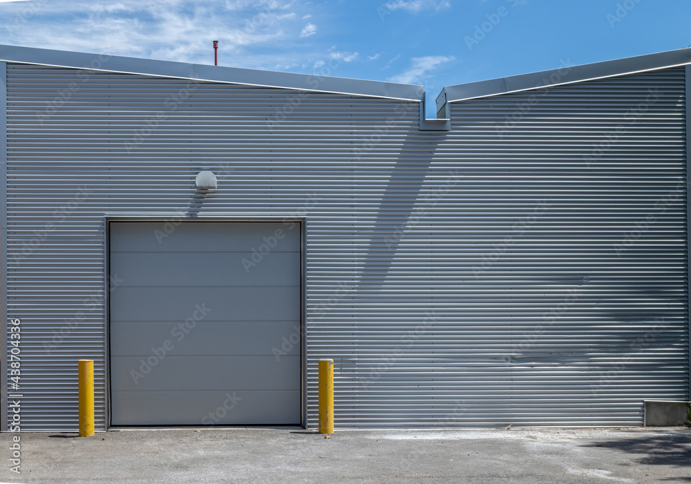 Exterior facade of large metal industrial building with grey corrugated ...