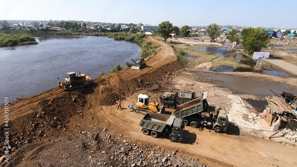 Construction of a dam made of earth and sand. Construction site near a ...