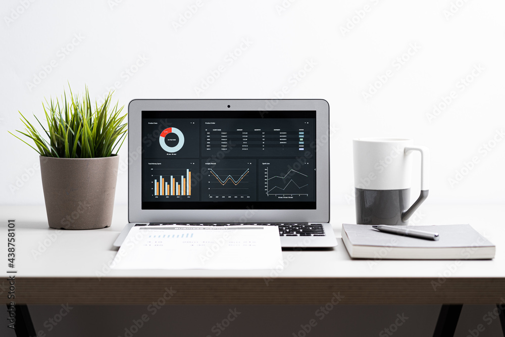 Laptop with graph chart report screen on work table. Home office or ...