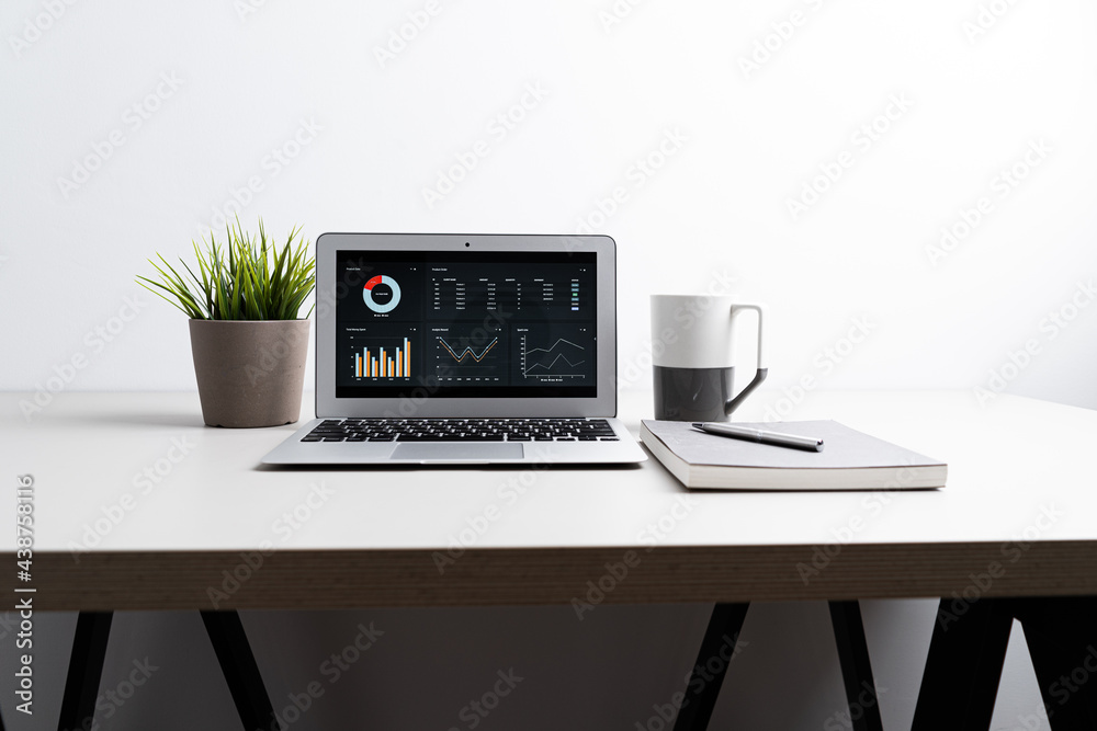 Laptop with graph chart report screen on work table. Home office or ...