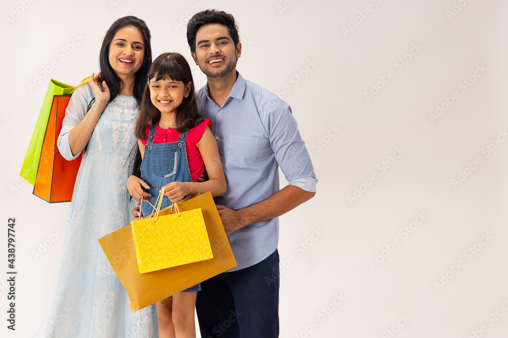 PORTRAIT OF A HAPPY FAMILY POSING WITH SHOPPING BAGS IN HAND Stock ...