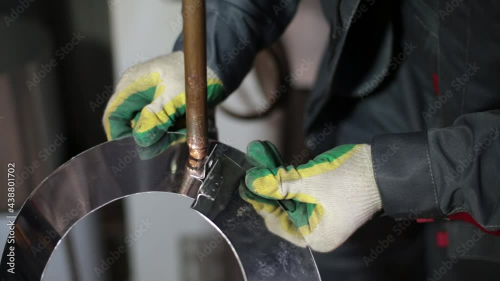 Spot welding machine. A worker welds a stainless steel sheet on a spot ...