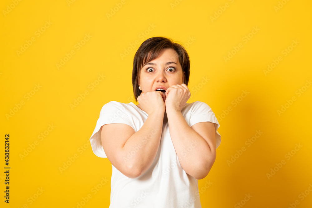 Scared pretty woman keeps hands on cheeks, looks with surprisement and ...