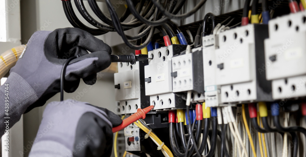 Electrician engineer tests electrical installations and wires on relay ...