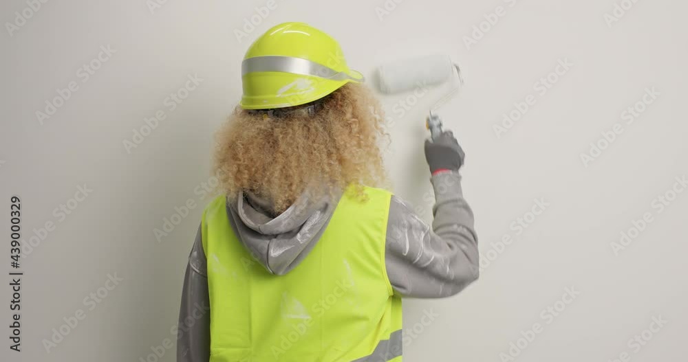 Renovation refurbishment concept. Busy female repairer paints wall in ...