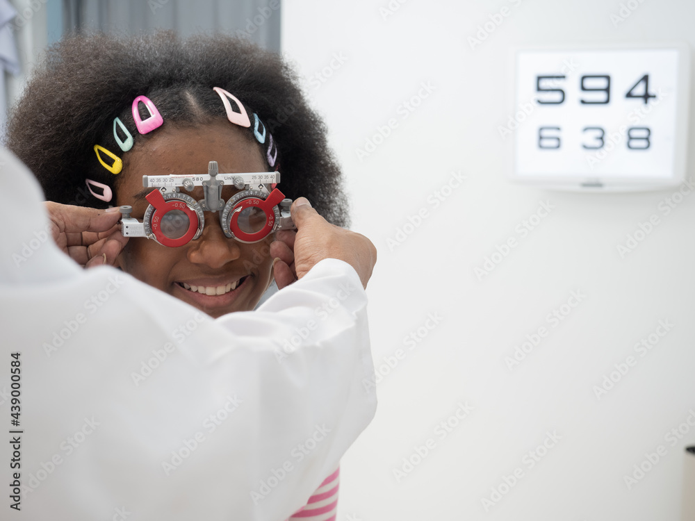 African girl putting optical trial frame to determine visual acuity ...