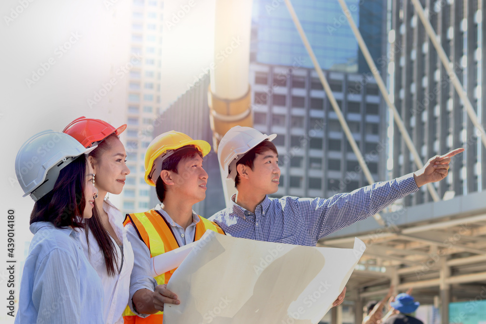 Group of four young Asian male and female engineers wearing safety vest ...