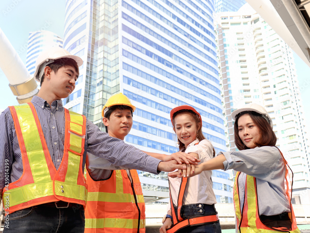 Group of four young Asian male and female engineers wearing safety vest ...