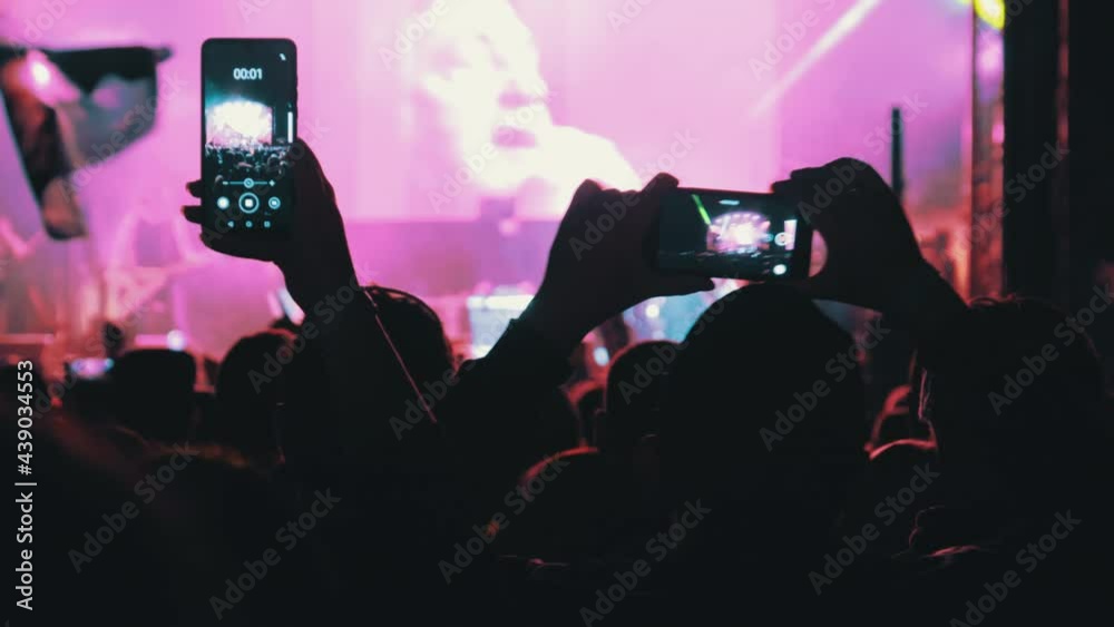 People filming rock concert on smartphones. Silhouettes crowd of people ...