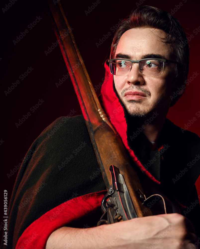 Portrait of soldier of past times in cape with his rifle slung over his ...