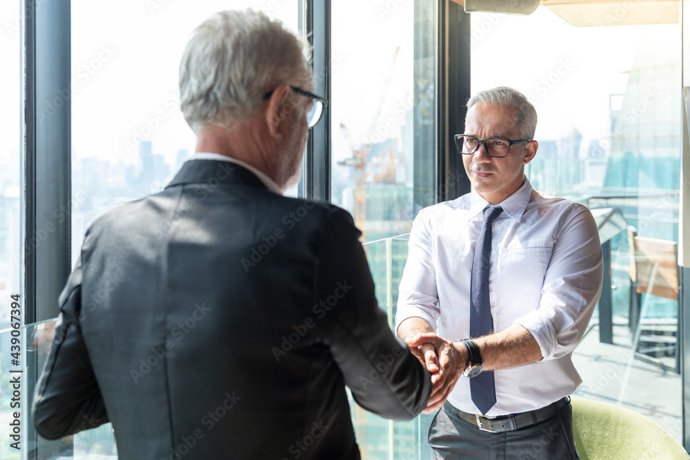 Two business men discussing their business together in a lobby of a ...