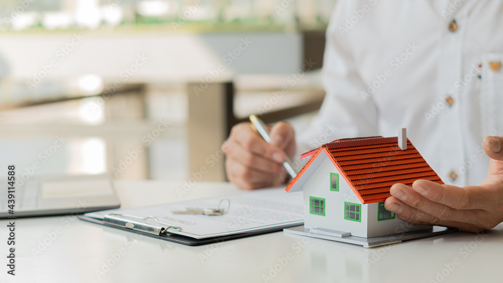 Real estate agents work in the office with paperwork. and offer a house ...