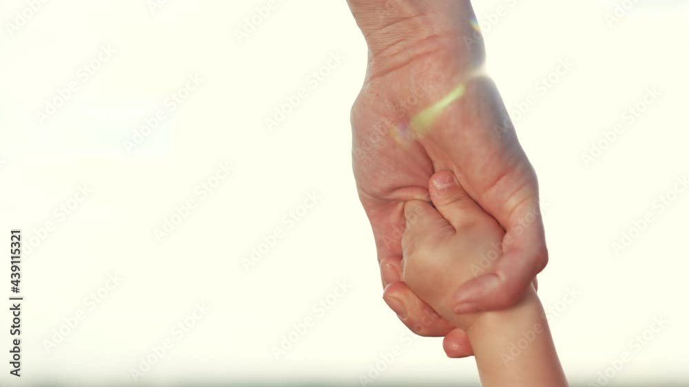 Helping hand. Mom holds baby by hand. Family teamwork. Happy kid holds ...