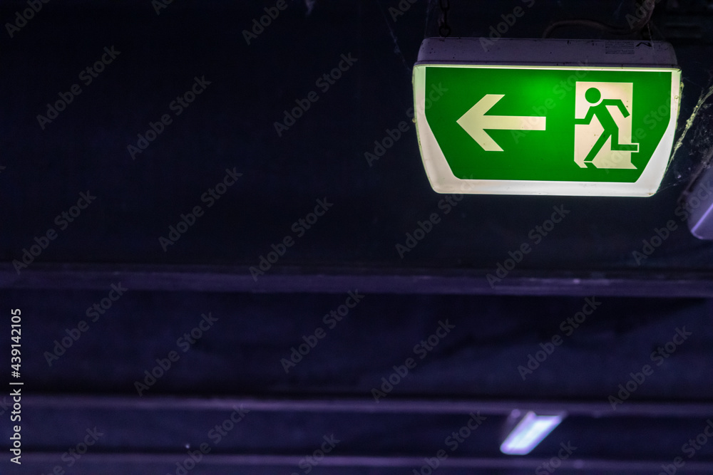 Green exit sign with running person and green arrow shows guidance ...