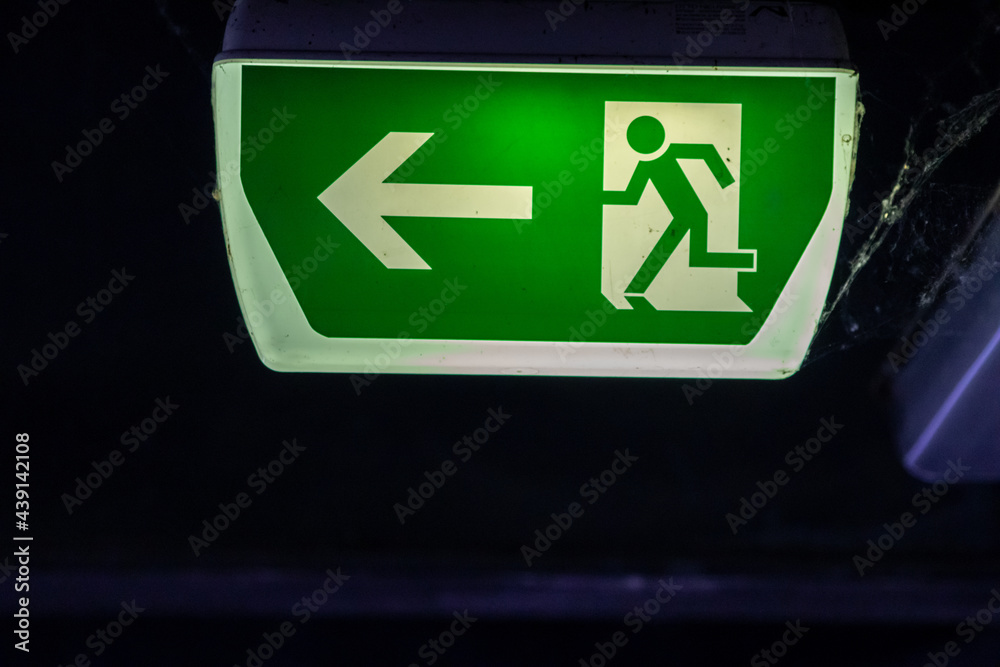 Green exit sign with running person and green arrow shows guidance ...