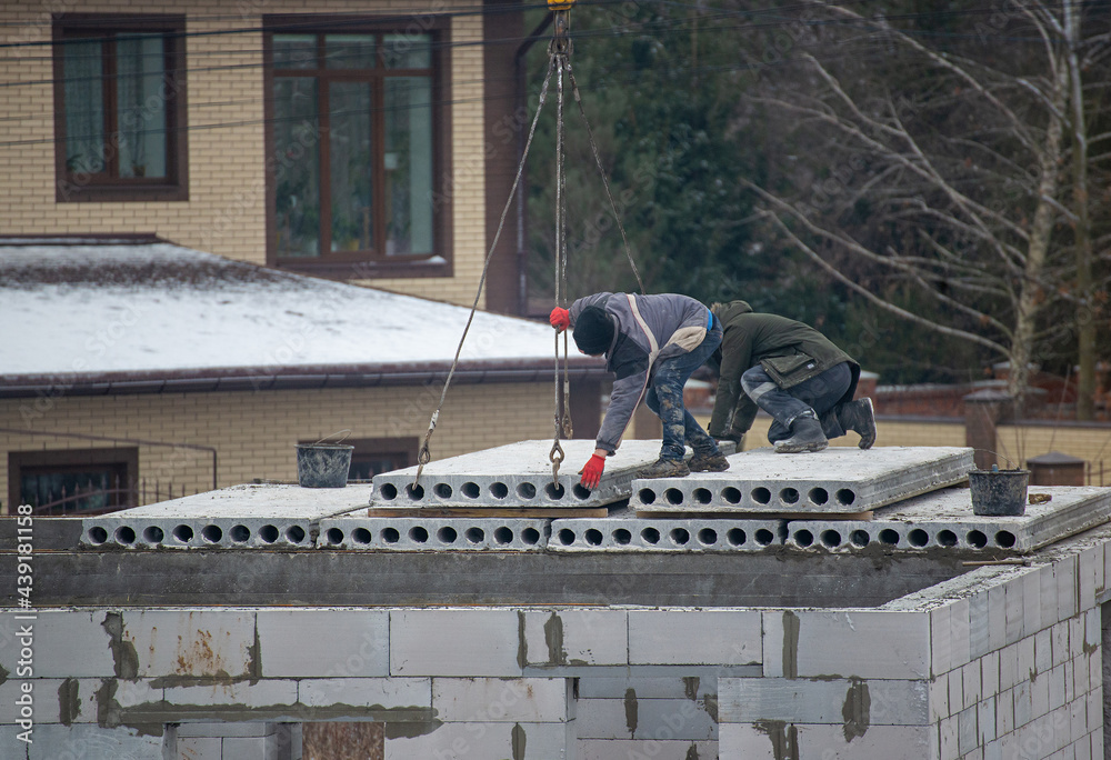 Builder worker installing concrete floor slab panel at building ...