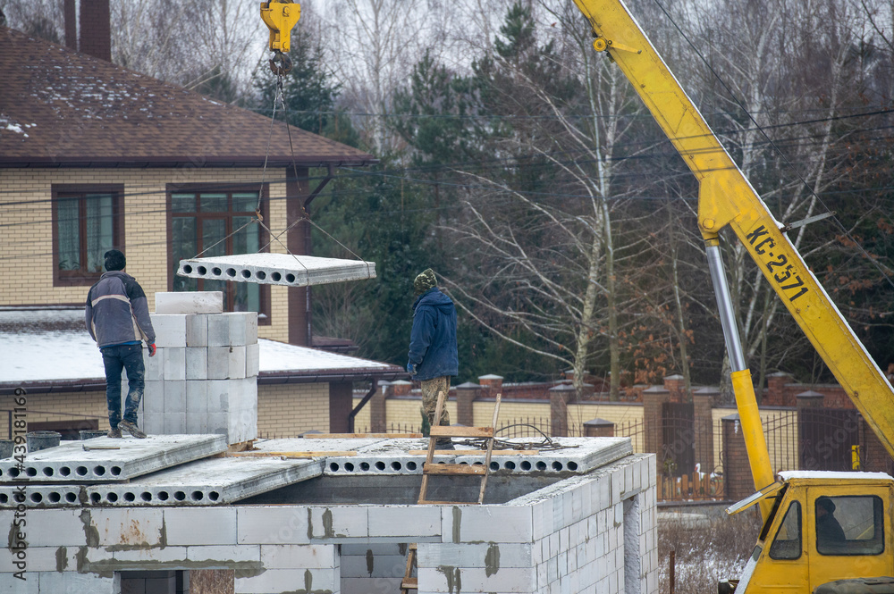 Builder worker installing concrete floor slab panel at building ...