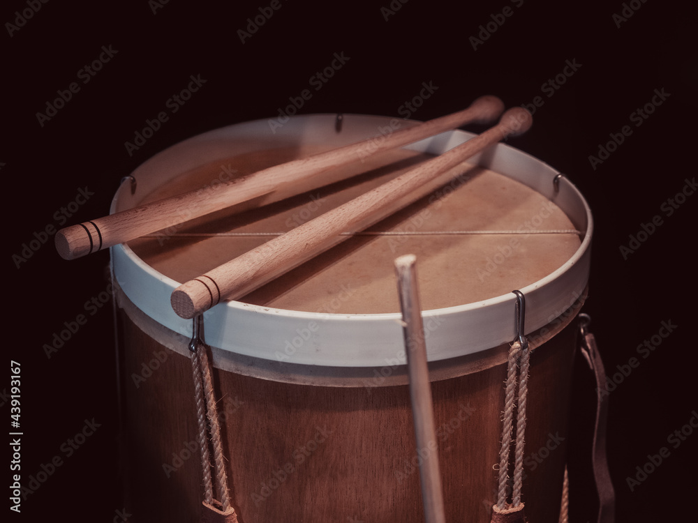 Old aesthetic drum with drumsticks on a black background in the style ...