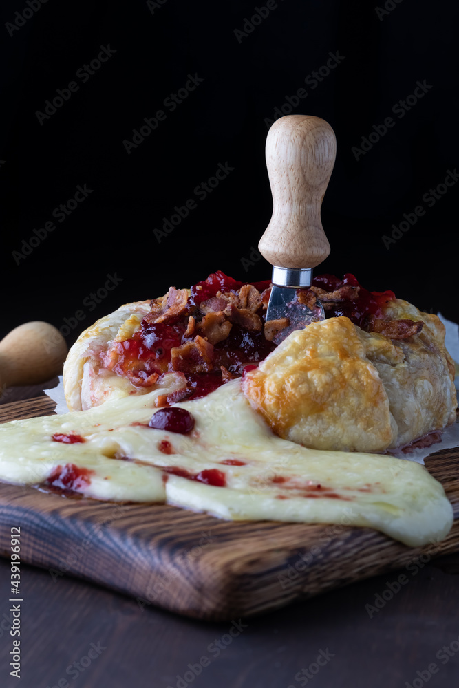 Brie cheese wrapped in puff pastry and topped with cranberry sauce and ...