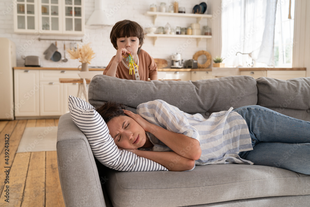 Exhausted young caucasian mom lying on couch in living room eyes closed ...