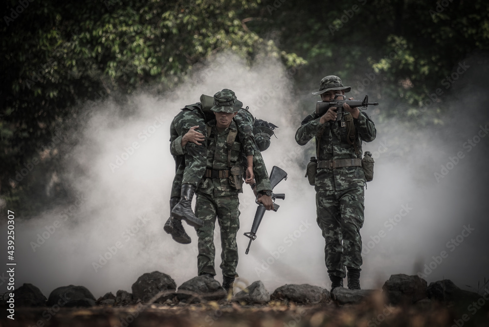 Soldiers are helping fellow soldier who is wounded in the battle. War ...