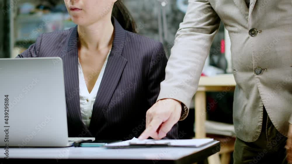 As a woman works at her desk, her male boss inappropriately touches her ...