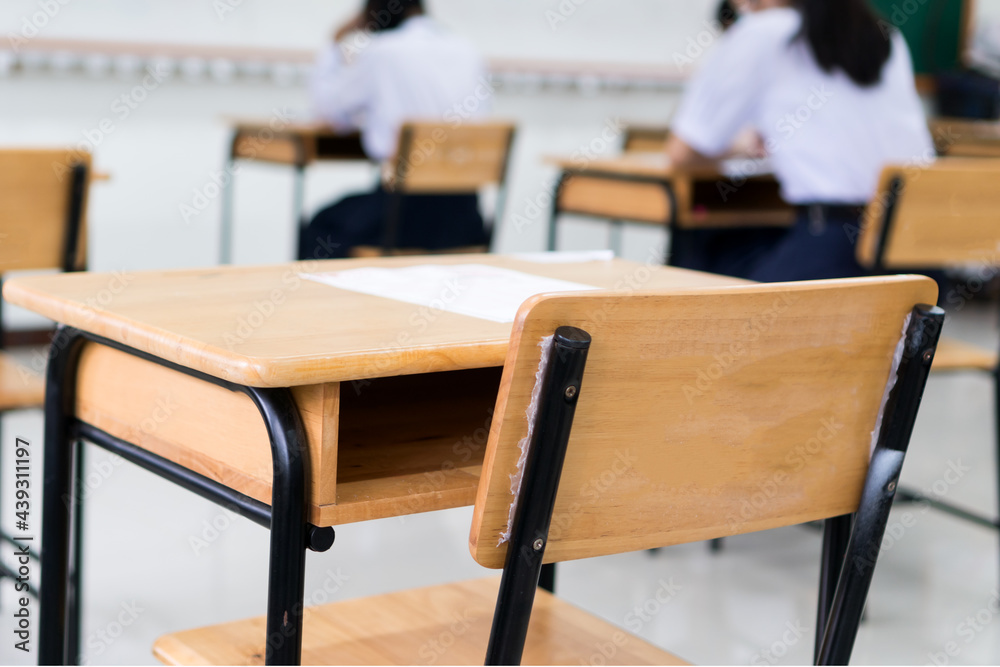 Class room tables and chairs with Paper documents of exam test on desk ...