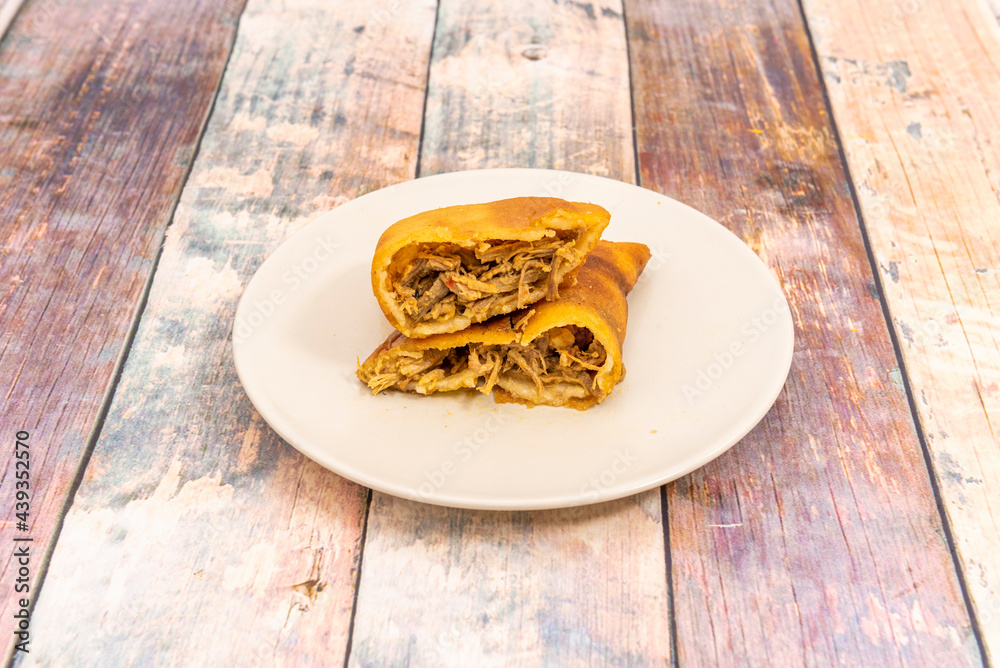 Corn patty cut in half to show the filling of shredded meat inside ...