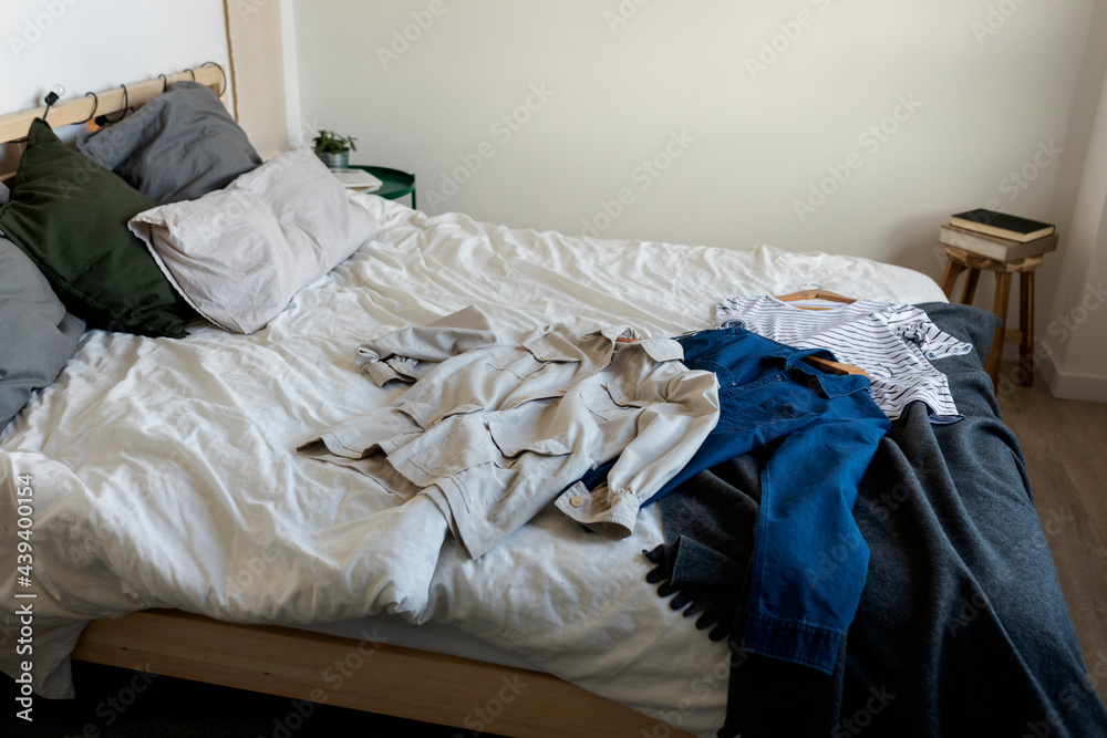 clothes laying on bed ready to be folded Stock Photo | Adobe Stock