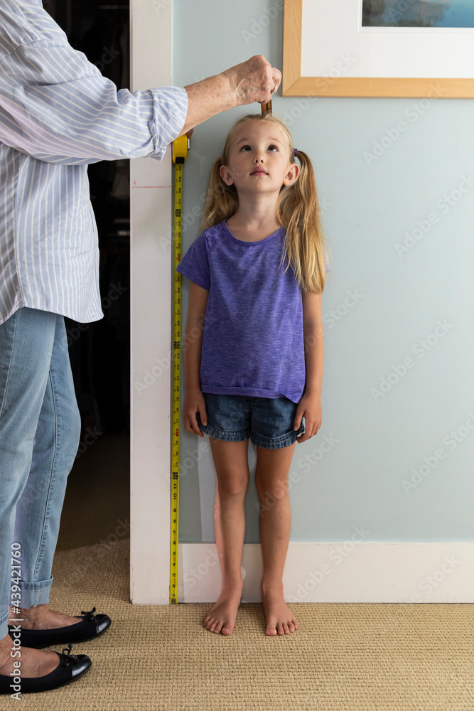 Young Girl Measuring her height Looking up Stock Photo | Adobe Stock
