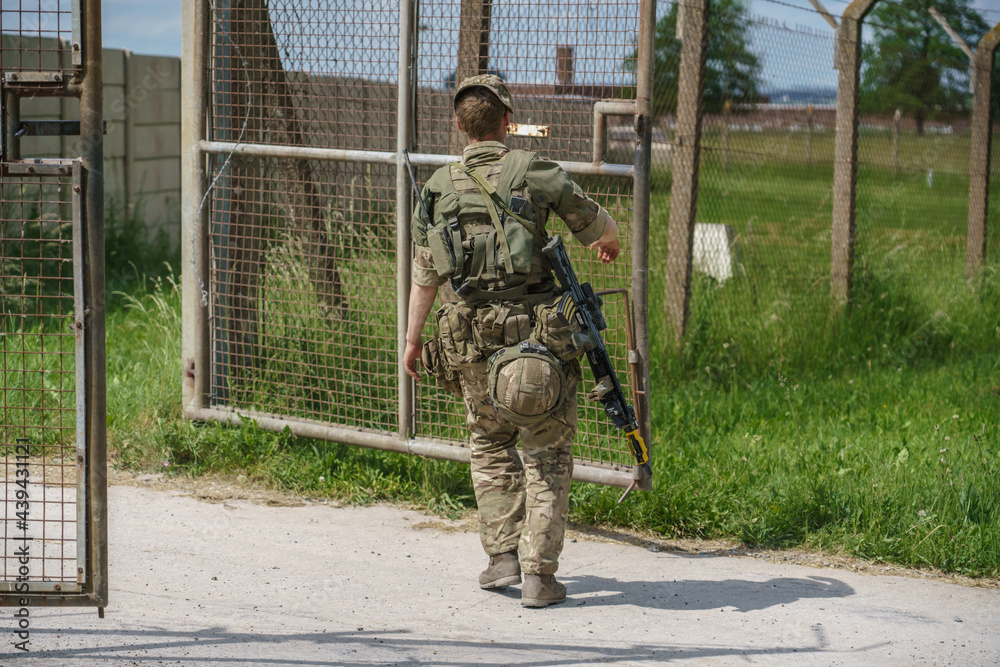 British Army soldier guarding the entrance to a secure base compound on ...