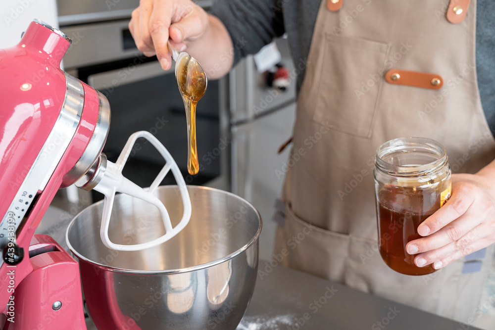 Man adding honey in a mixer Stock Photo | Adobe Stock