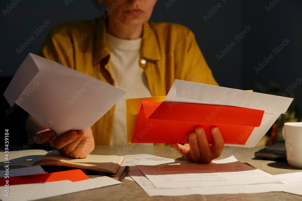 Crop female sorting mail at night Stock Photo | Adobe Stock