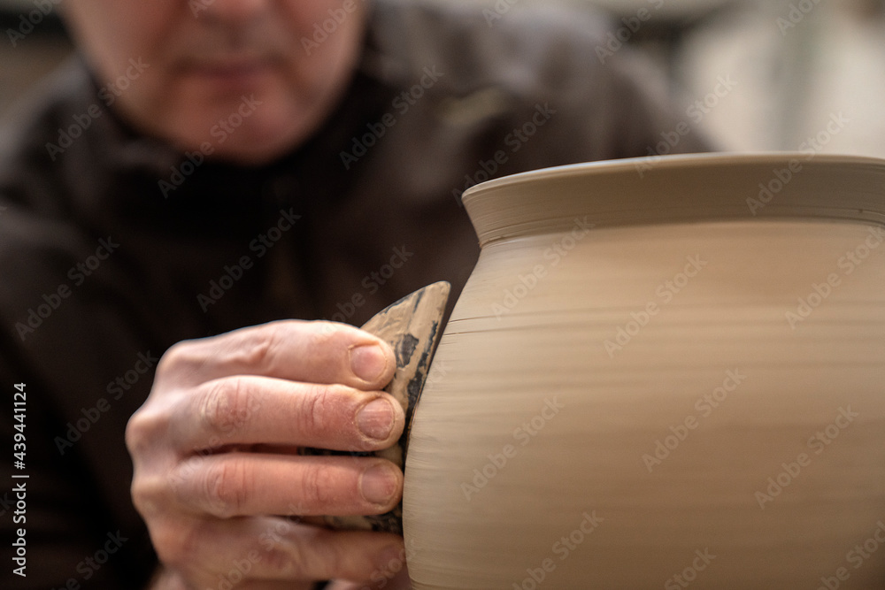 Selective focus on the hands of a man polishing a ceramic vessel Stock ...