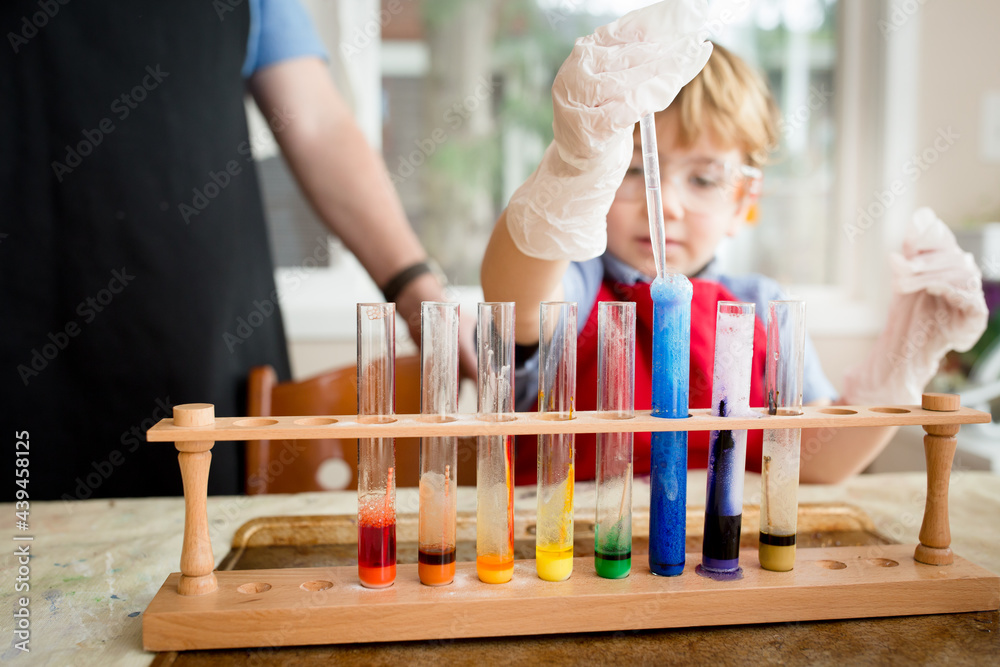 Boy pipettes liquid into overflowing test tube Stock Photo | Adobe Stock