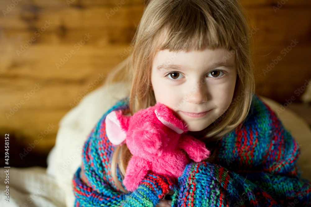 Girl holding stuffed animal looks up at camera Stock Photo | Adobe Stock