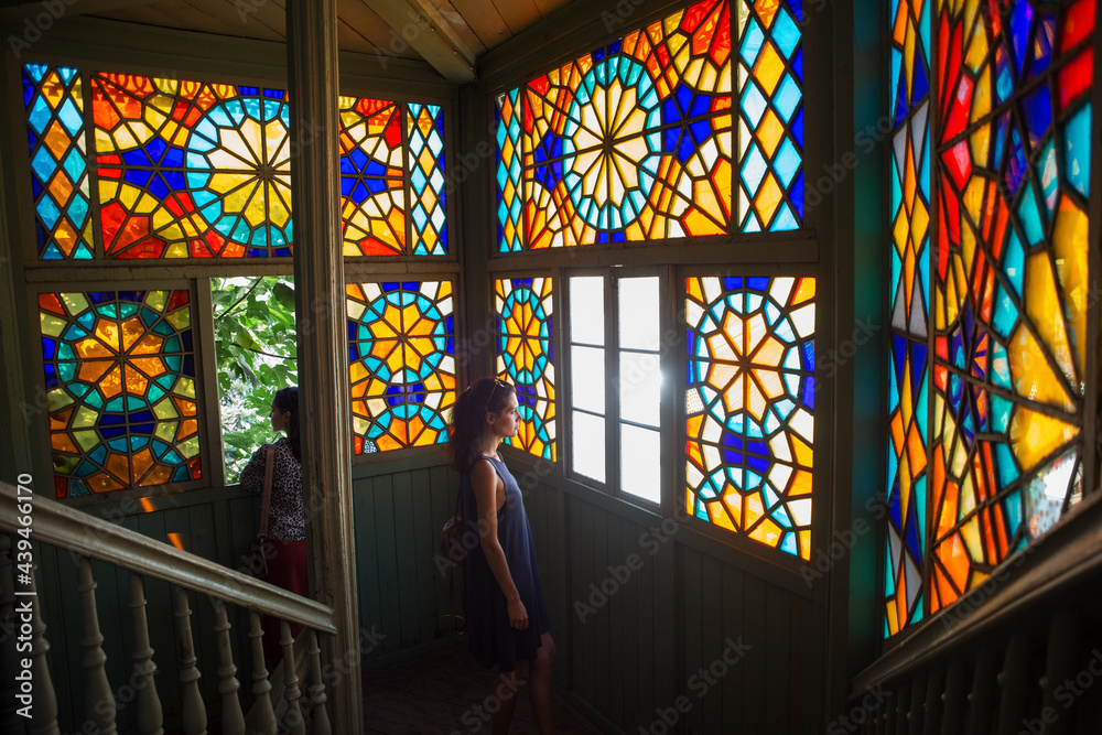 Women on stairs with vibrant stained glass windows Stock Photo | Adobe ...