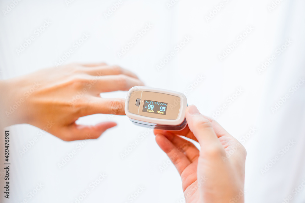 Woman measuring oxygen level with modern fingertip pulse oximeter for ...