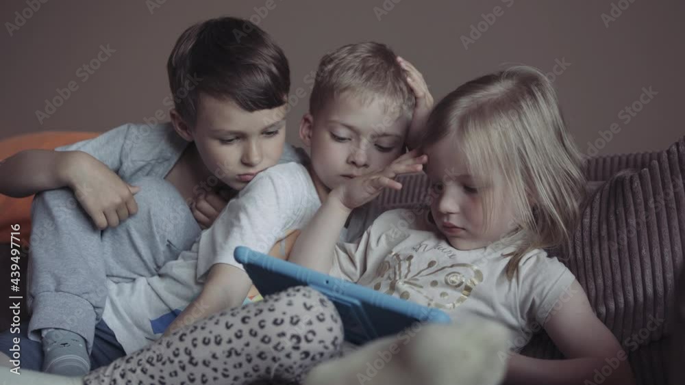 children play with tablet while sitting on the couch at home. child ...