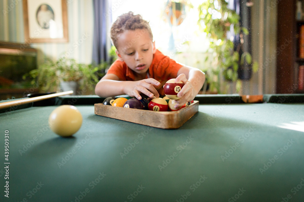 Boy racks pool balls Stock Photo | Adobe Stock