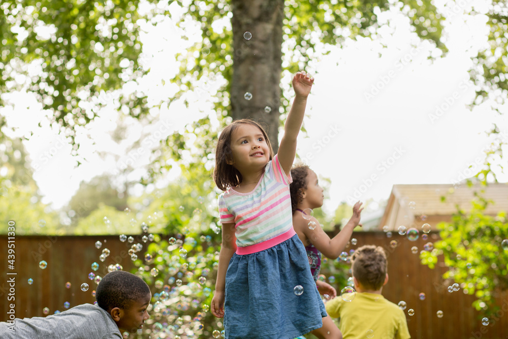 Cute girl grabs at tiny bubbles Stock Photo | Adobe Stock
