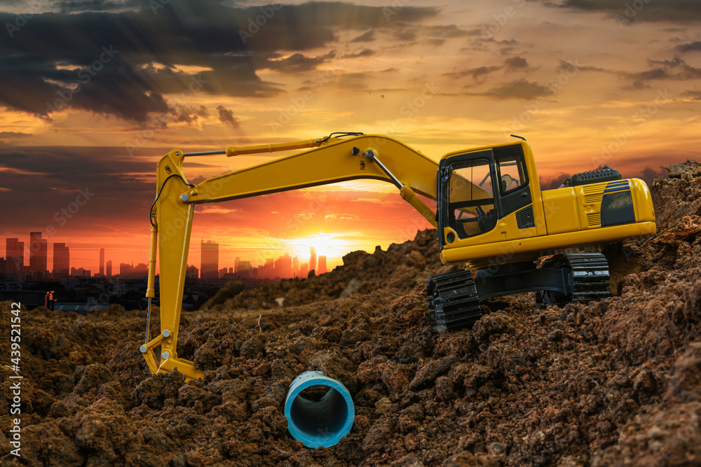 Excavator is digging in the construction site pipeline work on sunset ...