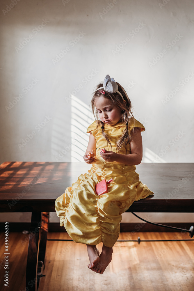 4 year old girl in yellow dress playing with makeup at home. Stock ...