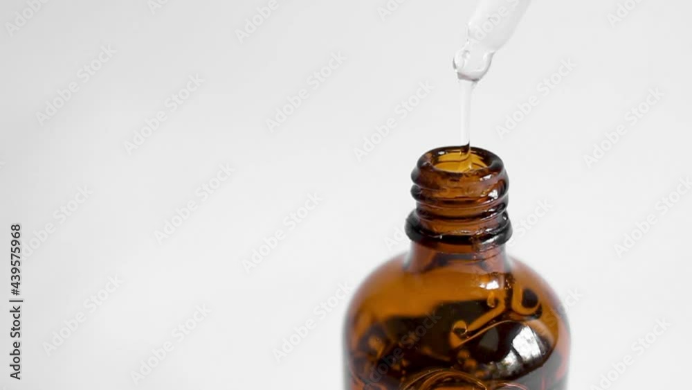 Vidéo Stock Opened brown glass bottle with pipette and pouring serum ...