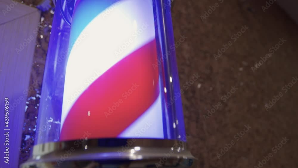 Barber pole rotating on wall in hairdresser shop. Barber pole spinning ...