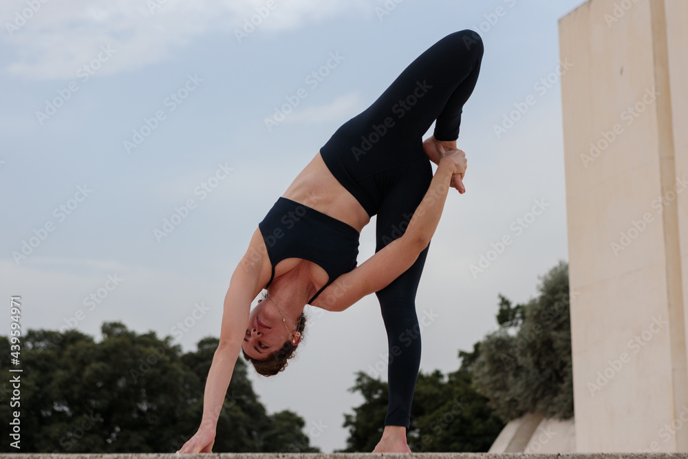 Foto de Thin athletic middle eastern woman stretching in a Yoga pose ...
